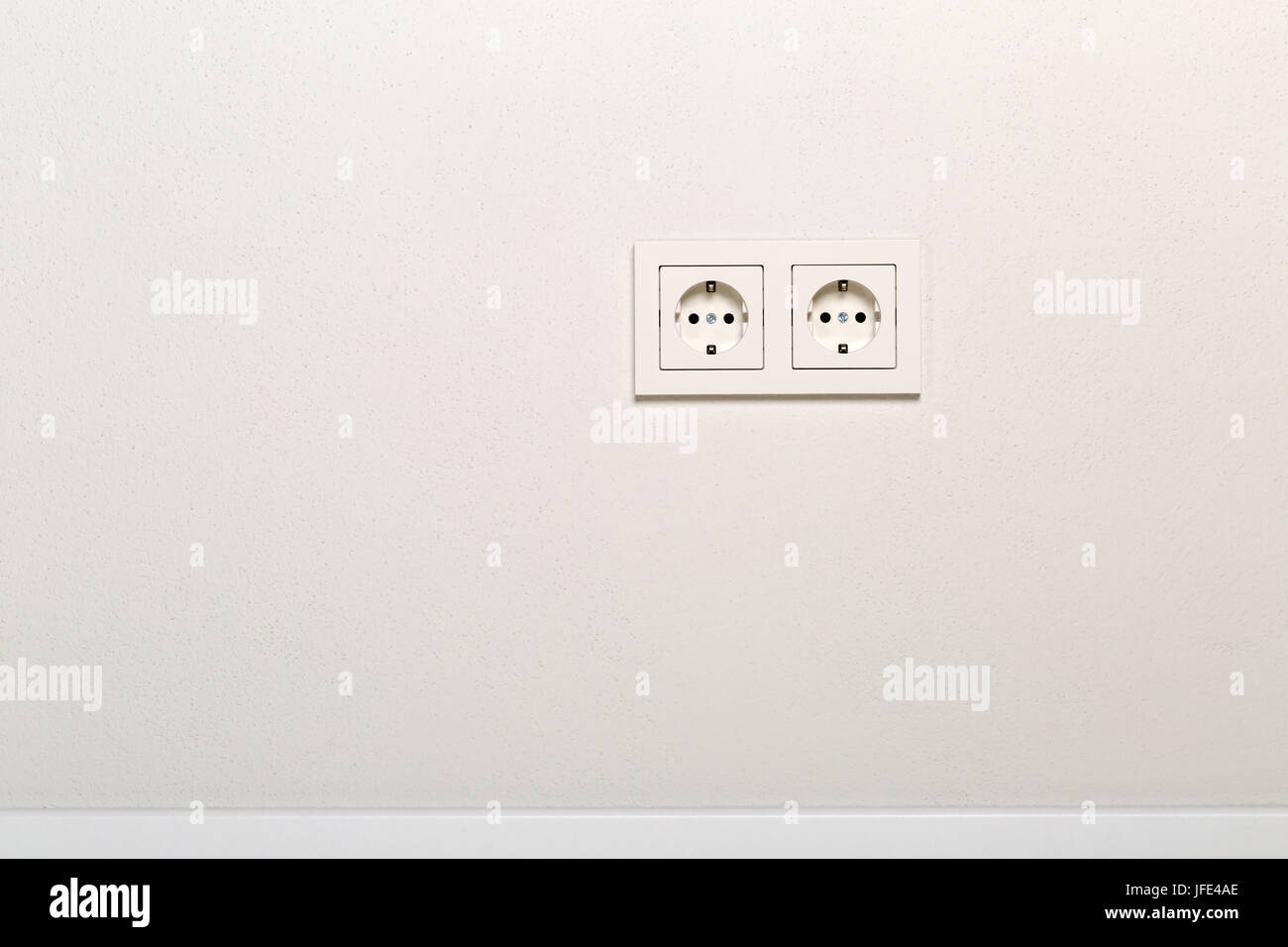 Empty, unplugged european wall outlet on white plaster wall with copy ...