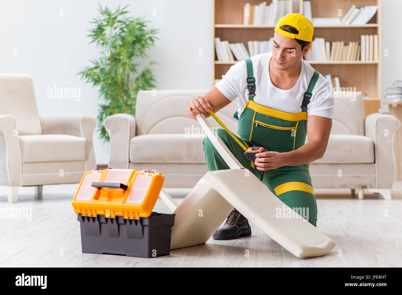 Worker repairing furniture at home Stock Photo - Alamy