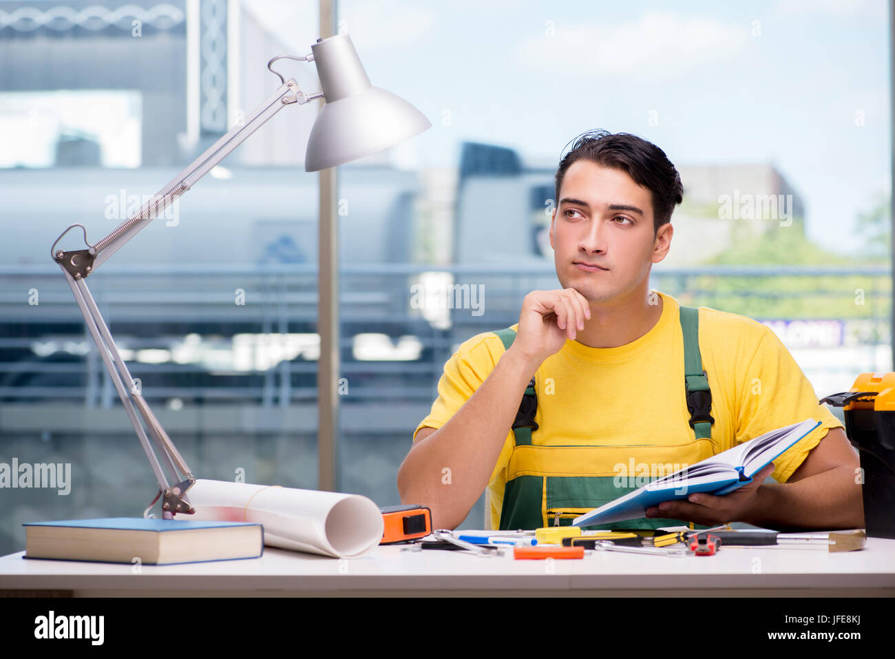 Construction worker sitting at the desk Stock Photo - Alamy