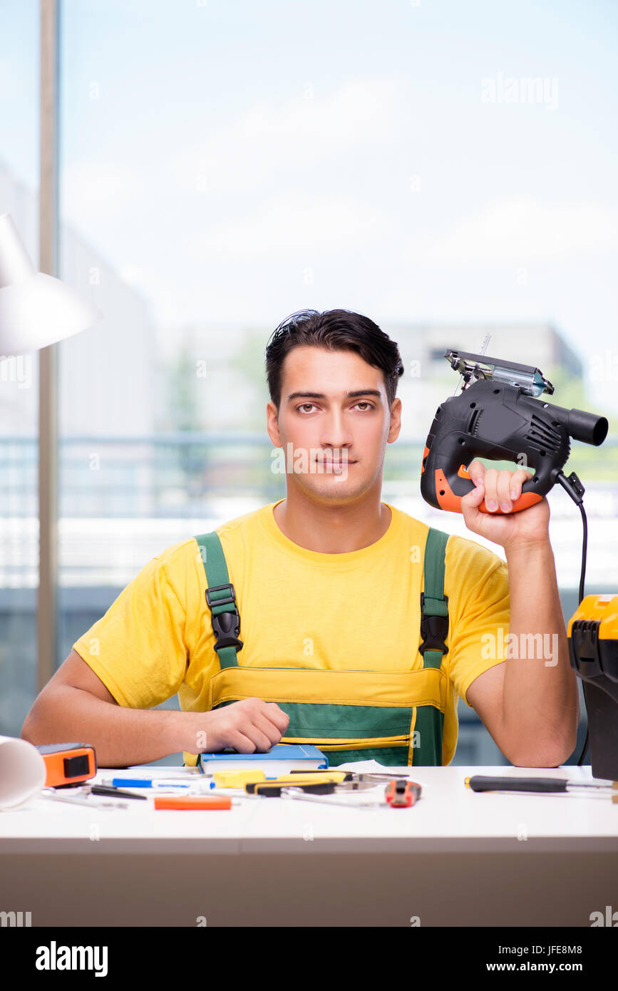 Construction worker sitting at the desk Stock Photo - Alamy