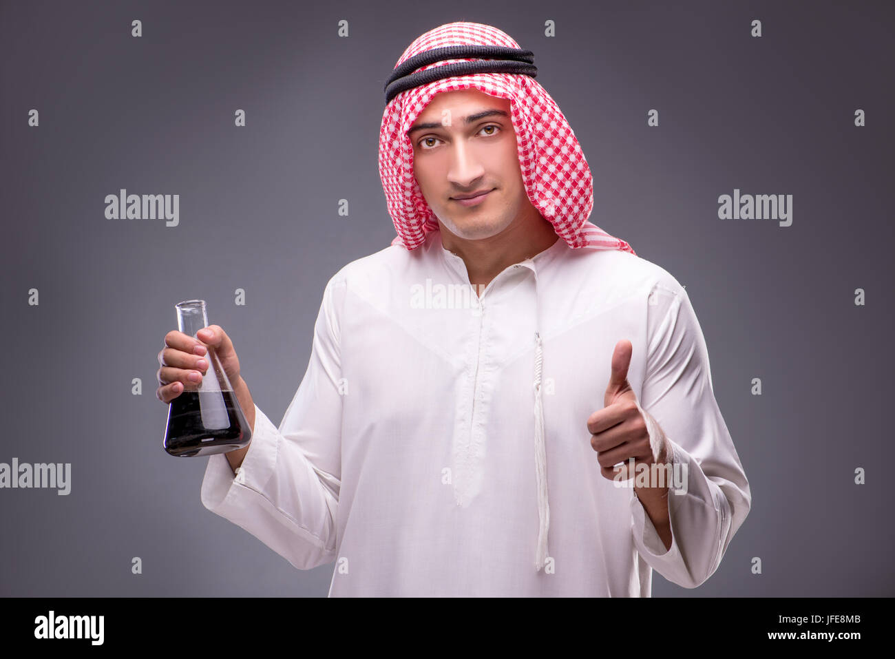 Arab with oil on gray background Stock Photo - Alamy
