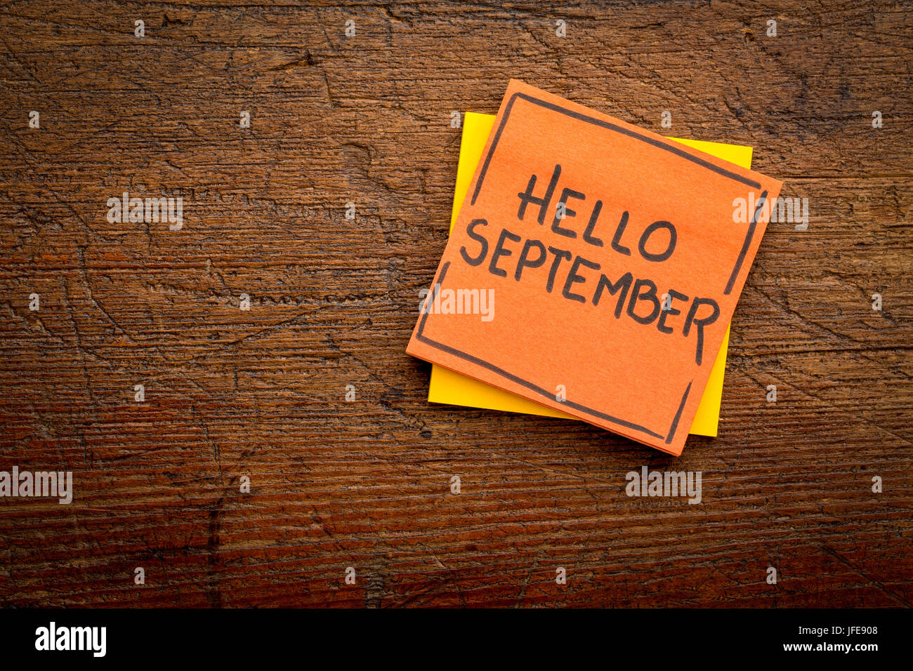 Hello September - handwriting on a sticky note against rustic wood ...