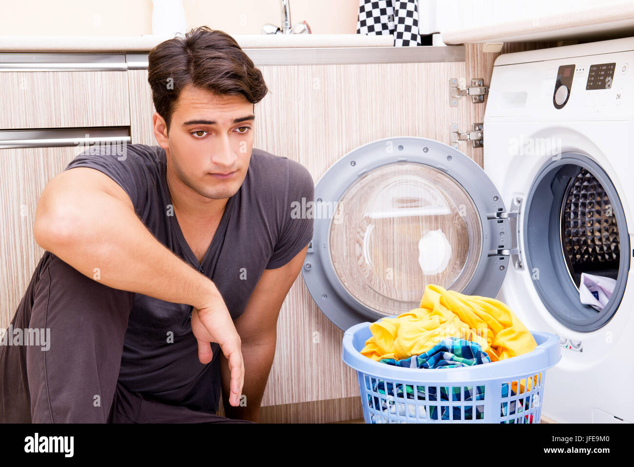 Young husband man doing laundry at home Stock Photo - Alamy