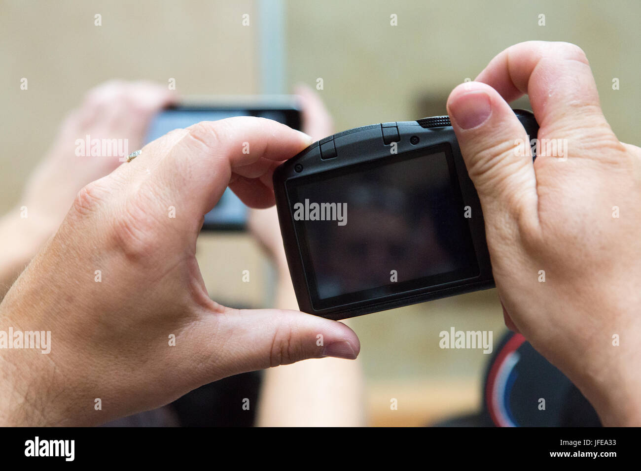 People holding their cameras to take pictures in the Louvre Museum ...
