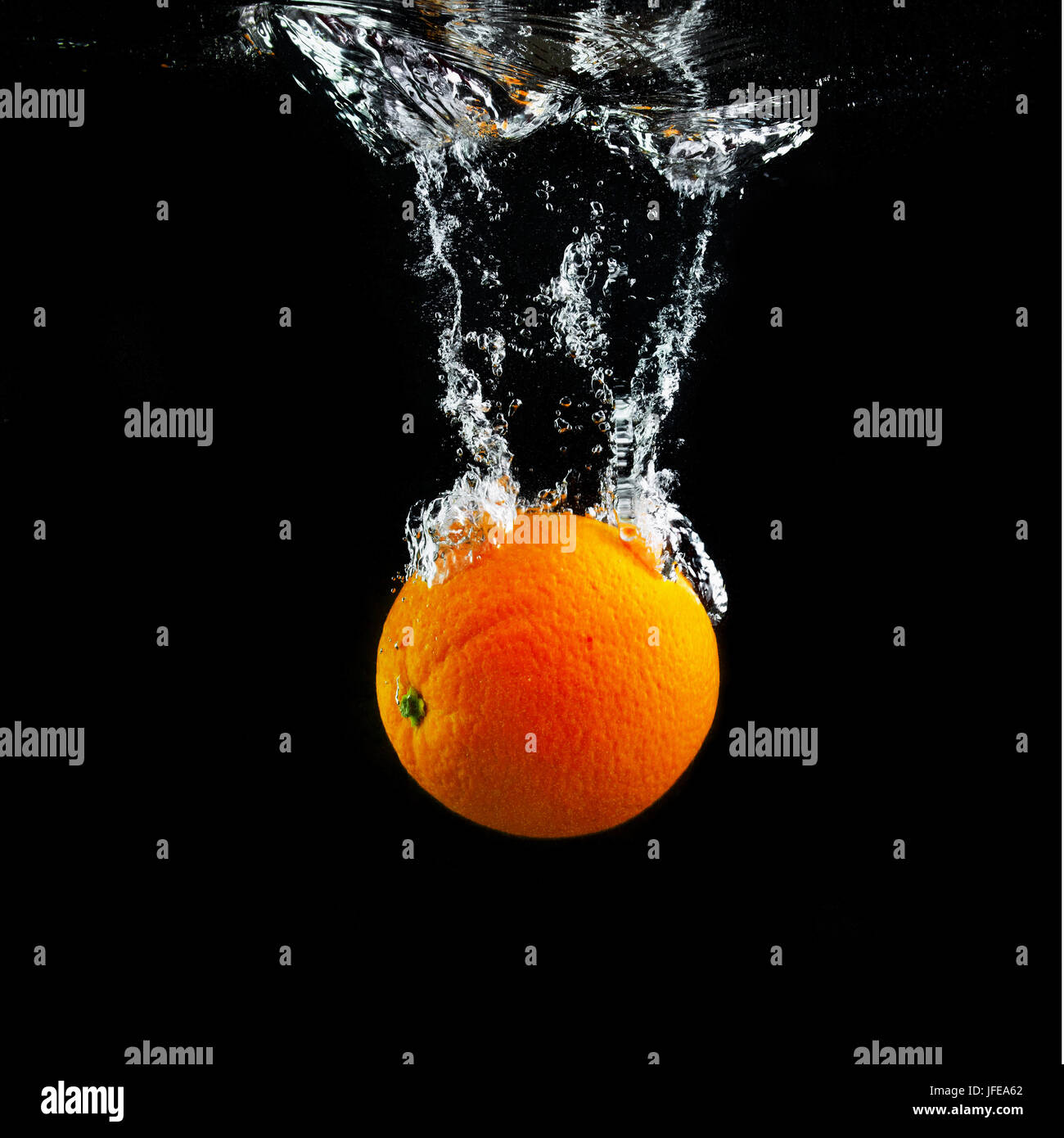 Orange falling into the water Stock Photo - Alamy