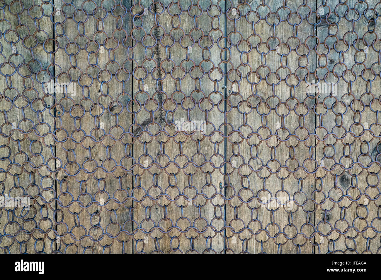 background and texture of vintage chain mesh against weathered wood ...