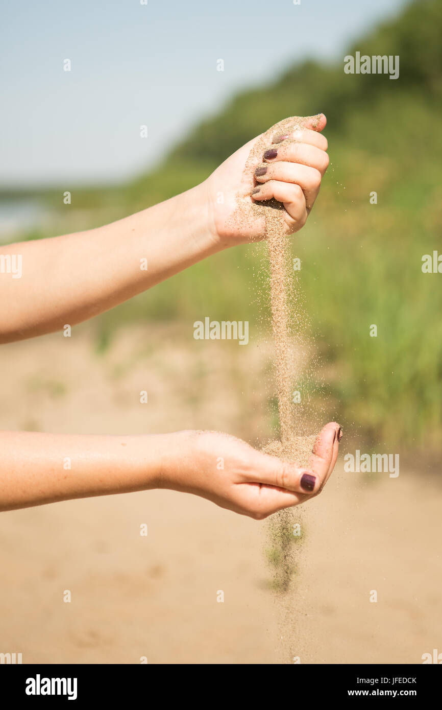 sand running through hands of woman in the beach Stock Photo - Alamy