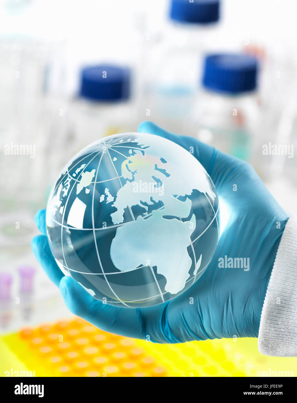 Global research, conceptual image. Scientist holding a globe with a ...