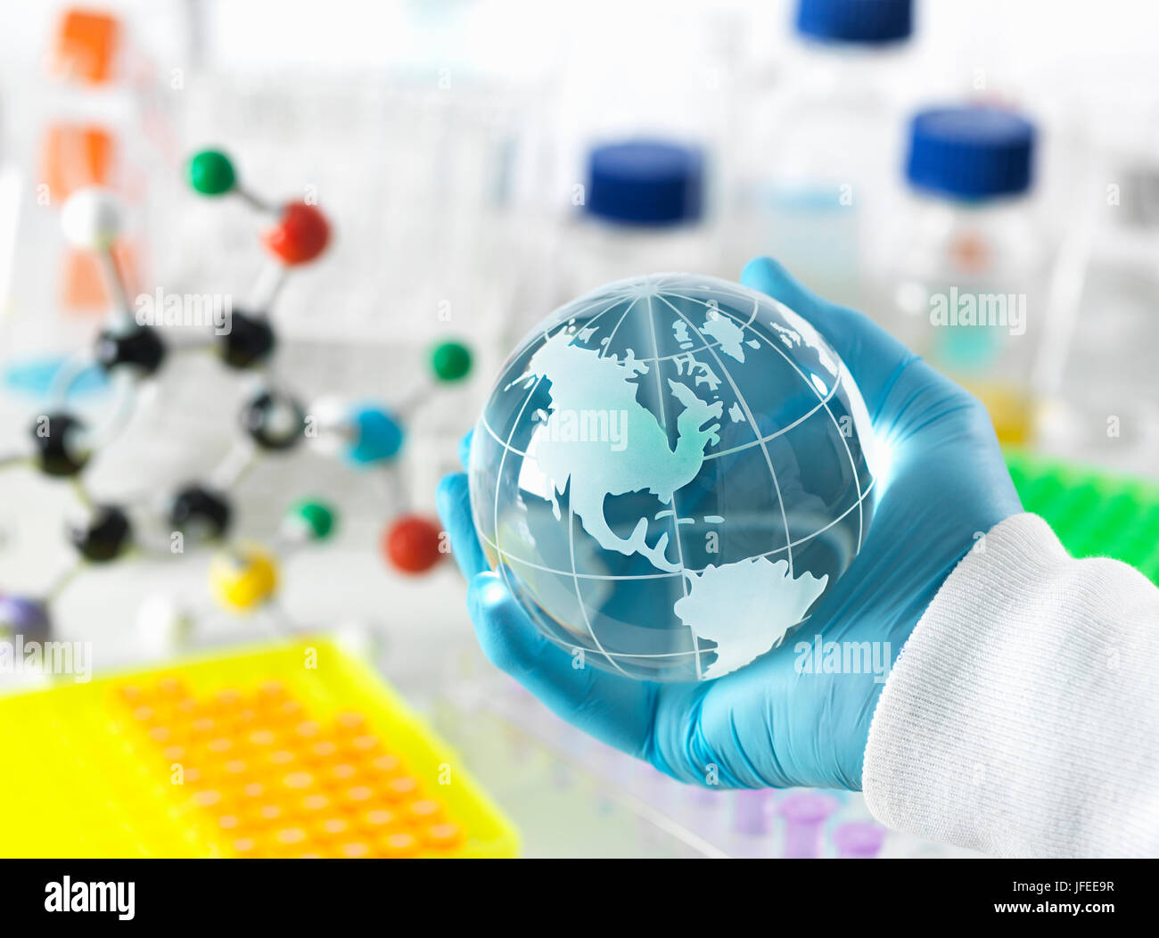 Global research, conceptual image. Scientist holding a globe with a ...