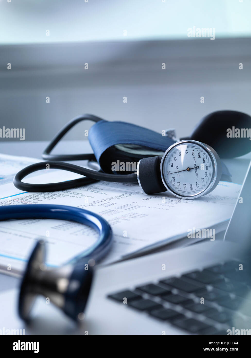 Blood pressure gauge and stethoscope sitting on a doctors desk Stock ...