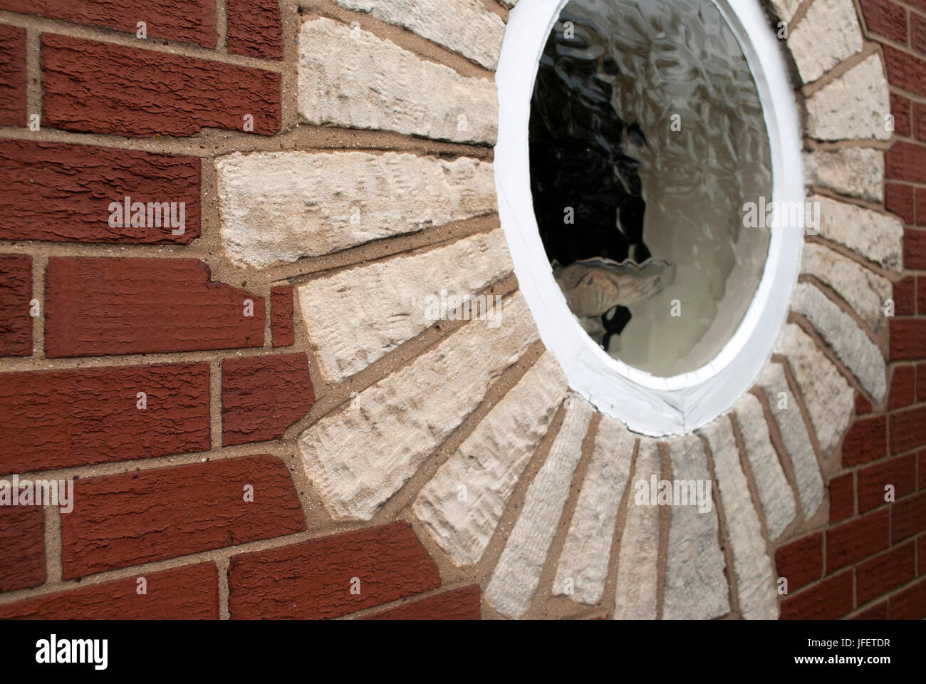 Round window surrounded by stone in red brick wall Stock Photo - Alamy