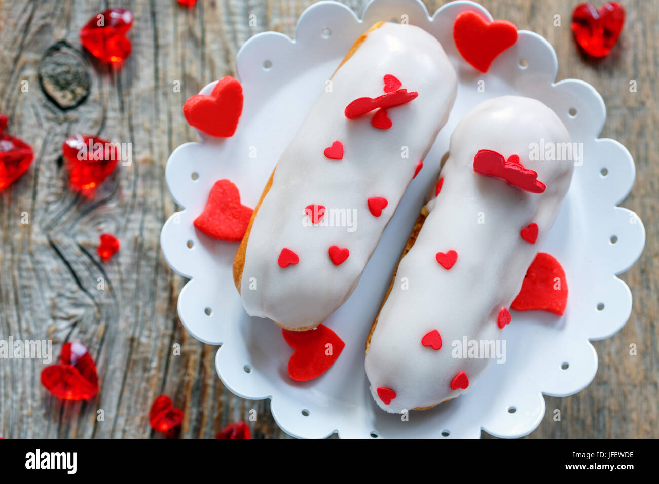 Vanilla eclairs with red marzipan hearts Stock Photo - Alamy