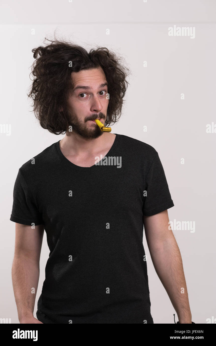 Portrait of a man in party hat blowing in whistle isolated on a white ...