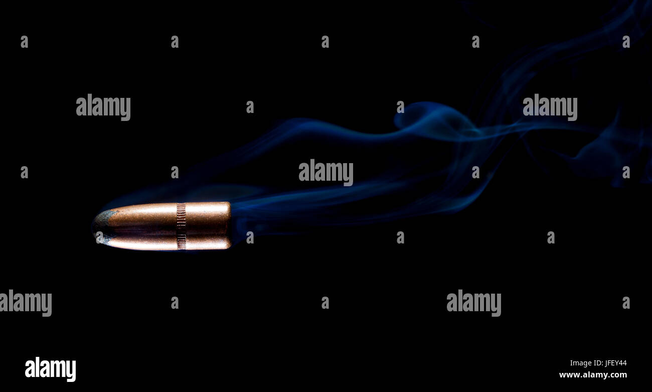 Copper bullet with blue smoke behind on a black background Stock Photo ...