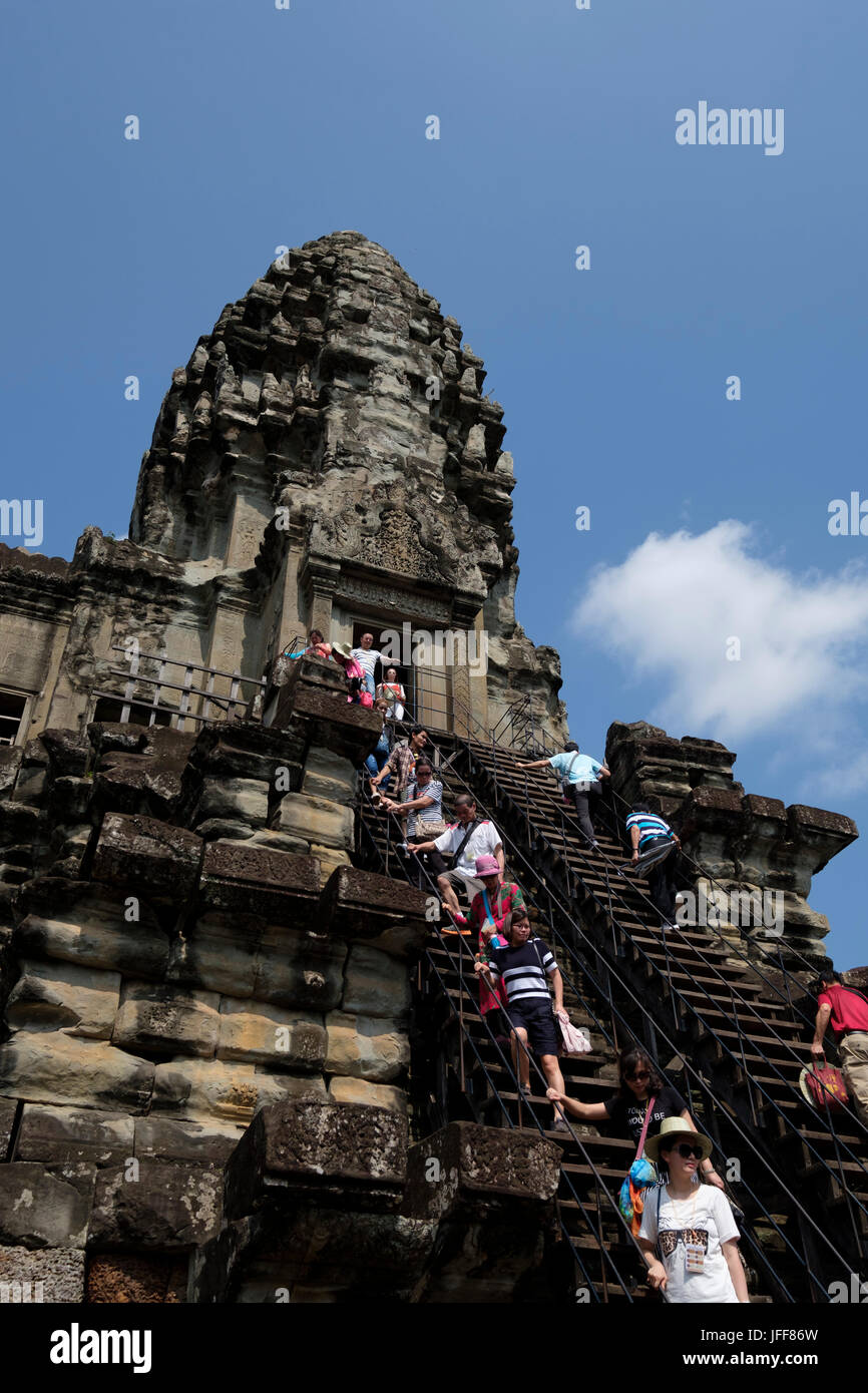 Tourists climbing the steep steps of a tower at the Angkor Wat temple ...