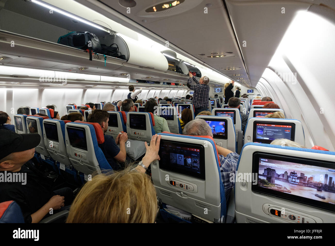 Passenger using an airplane's entertainment system Stock Photo - Alamy