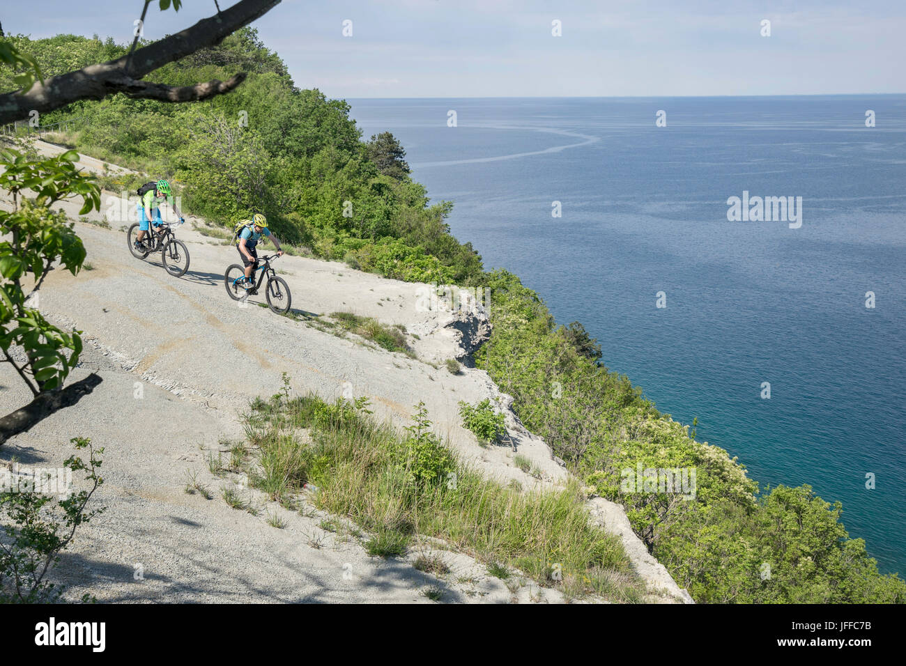 Bikers riding on rocky cliff by sea Stock Photo - Alamy