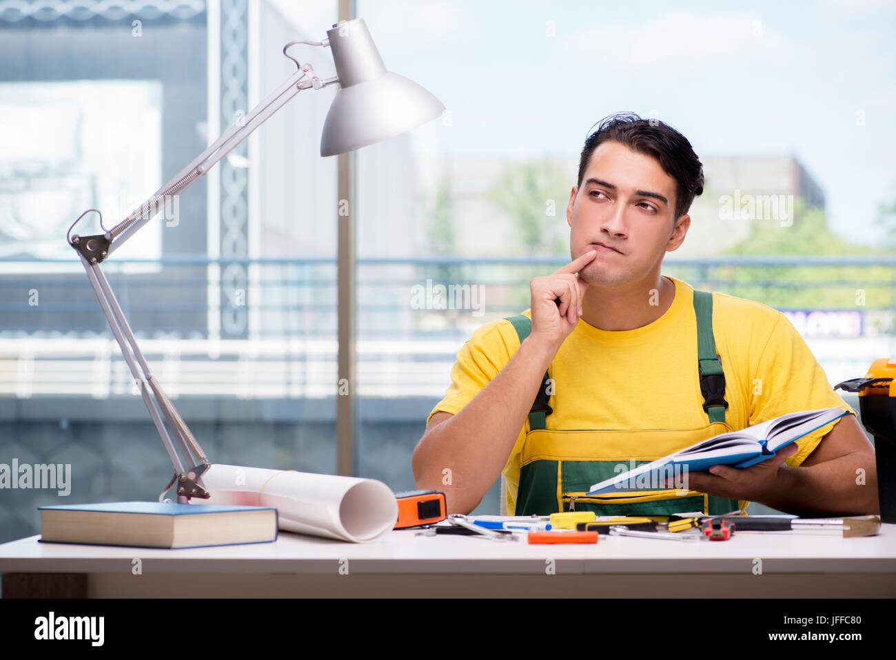 Construction worker sitting at the desk Stock Photo - Alamy