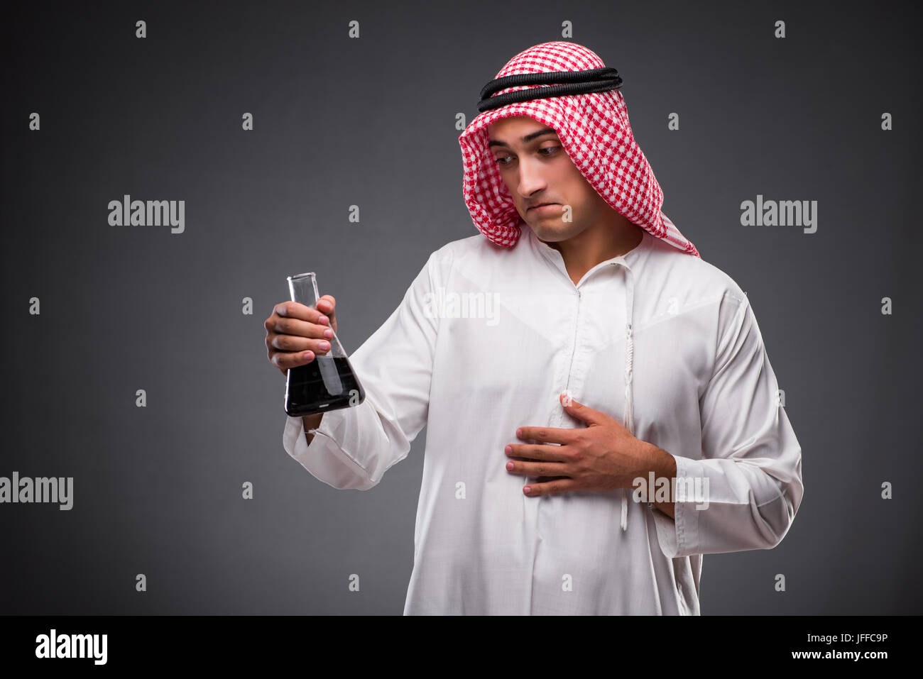 Arab with oil on gray background Stock Photo - Alamy