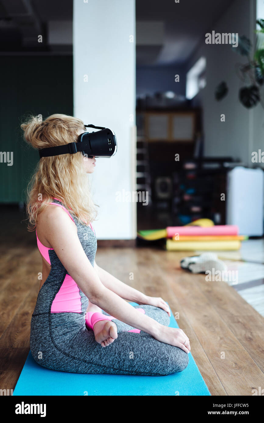 Woman in yoga class with VR headset Stock Photo - Alamy
