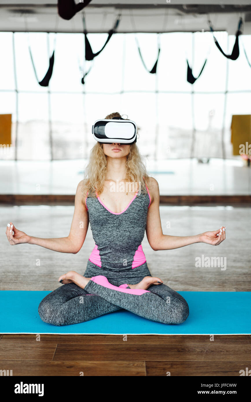 Woman in yoga class with VR headset Stock Photo - Alamy