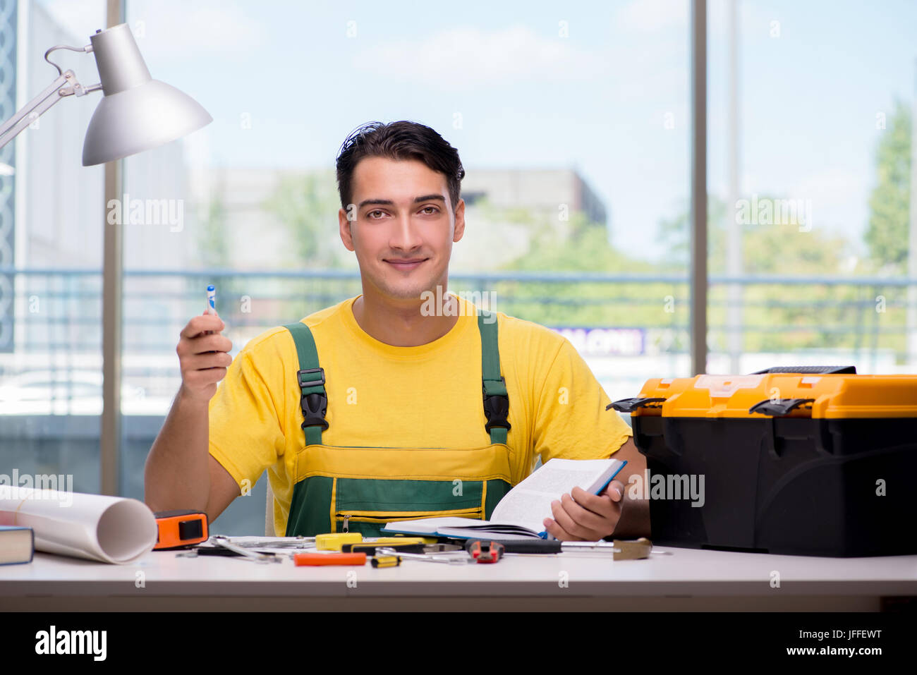 Construction worker sitting at the desk Stock Photo - Alamy