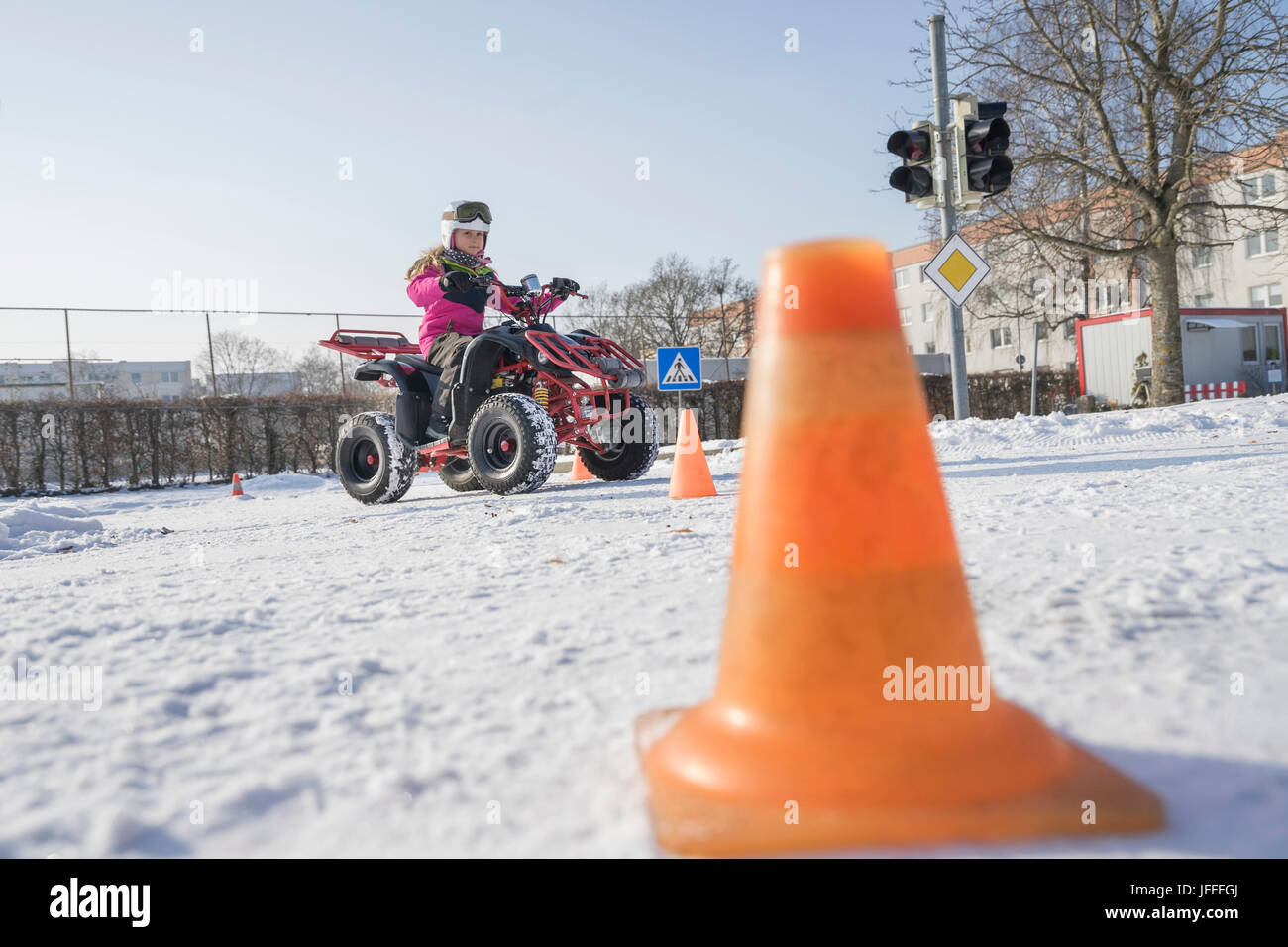 Girl riding quad bike on snow covered road Stock Photo - Alamy