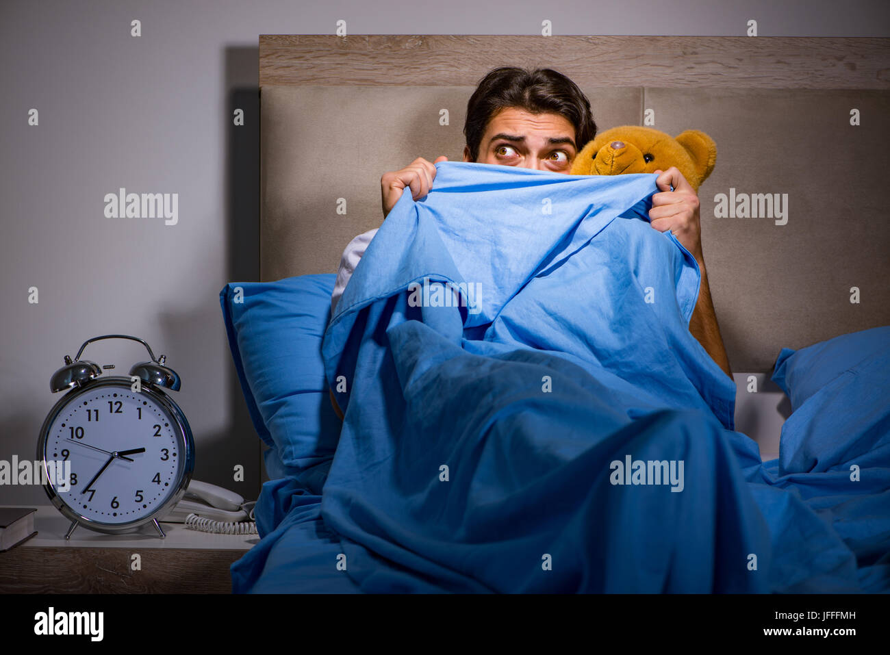 Young man scared in bed Stock Photo - Alamy