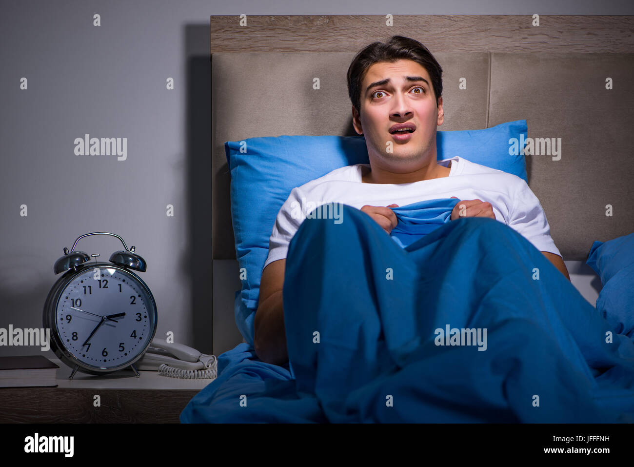 Young man scared in bed Stock Photo - Alamy