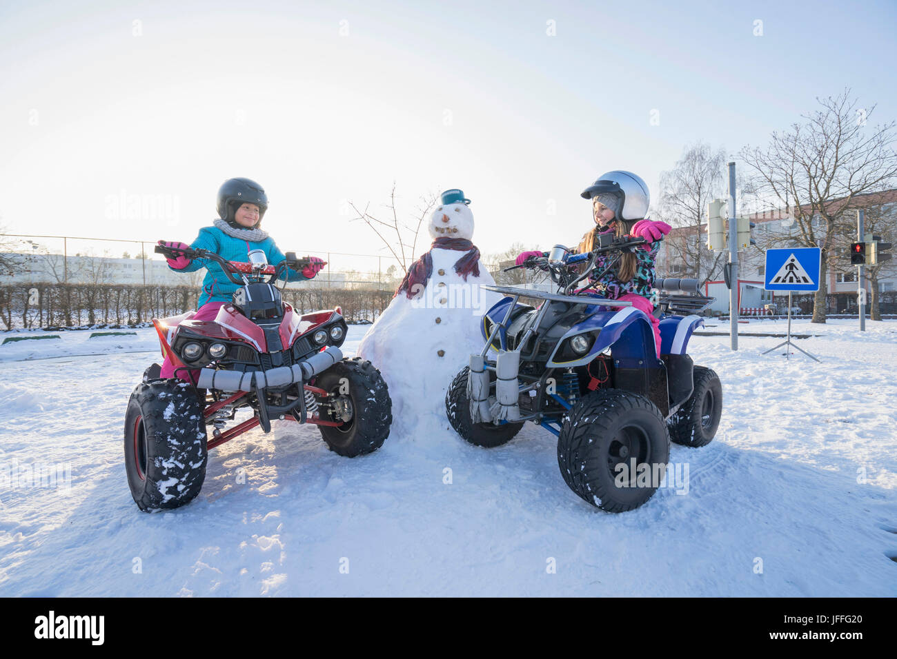 Girls riding quad bike on snow field Stock Photo - Alamy