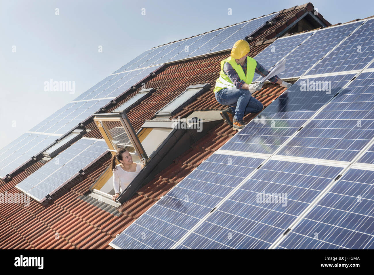 Engineer and client on rooftop discussing about solar panels Stock ...