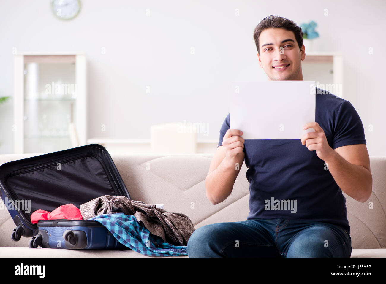 Man going on vacation packing his suitcase Stock Photo - Alamy