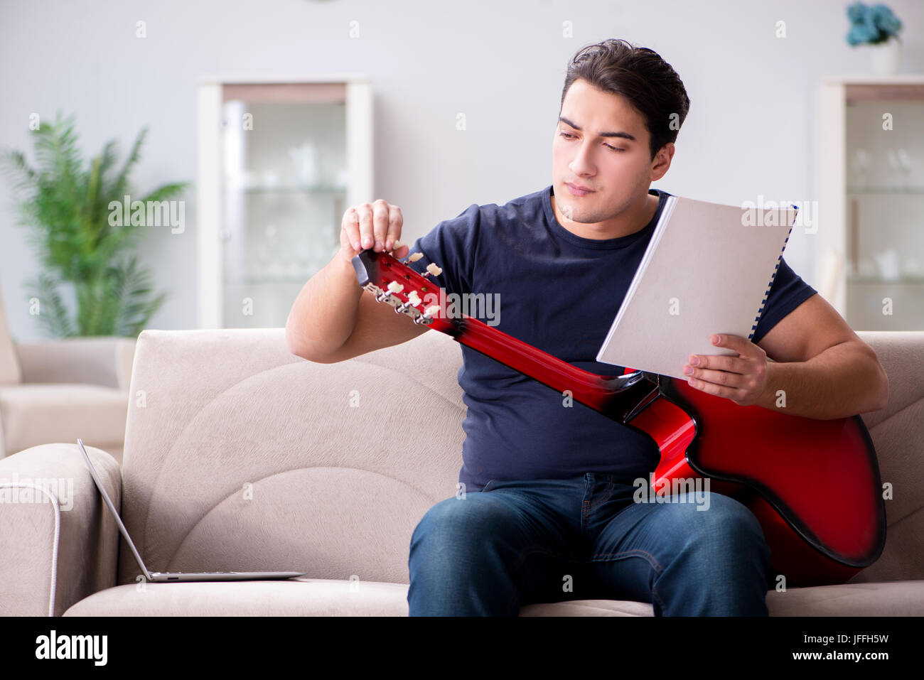 Handsome man tuning guitar hi-res stock photography and images - Alamy