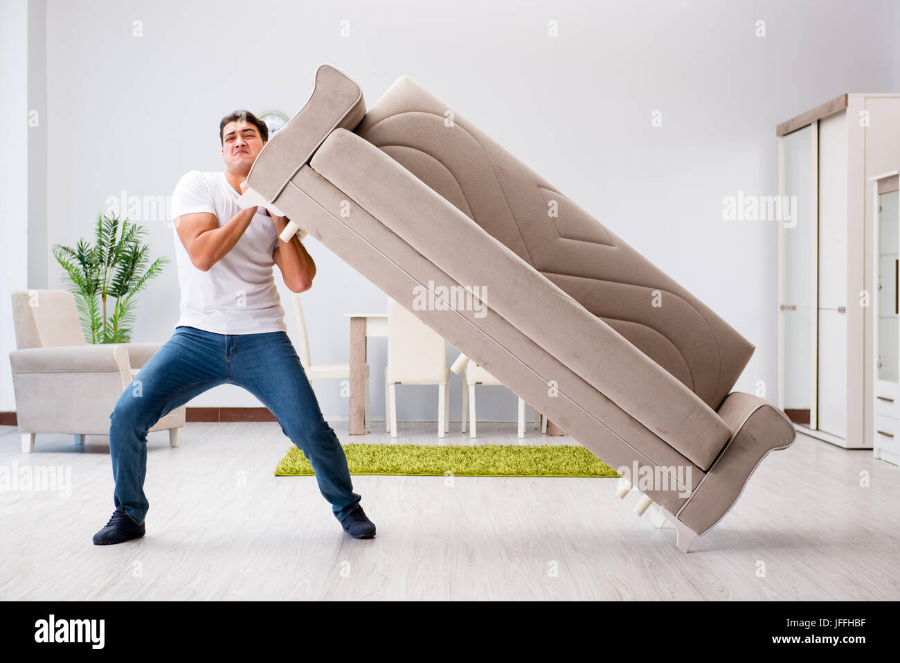 Young man moving furniture at home Stock Photo - Alamy