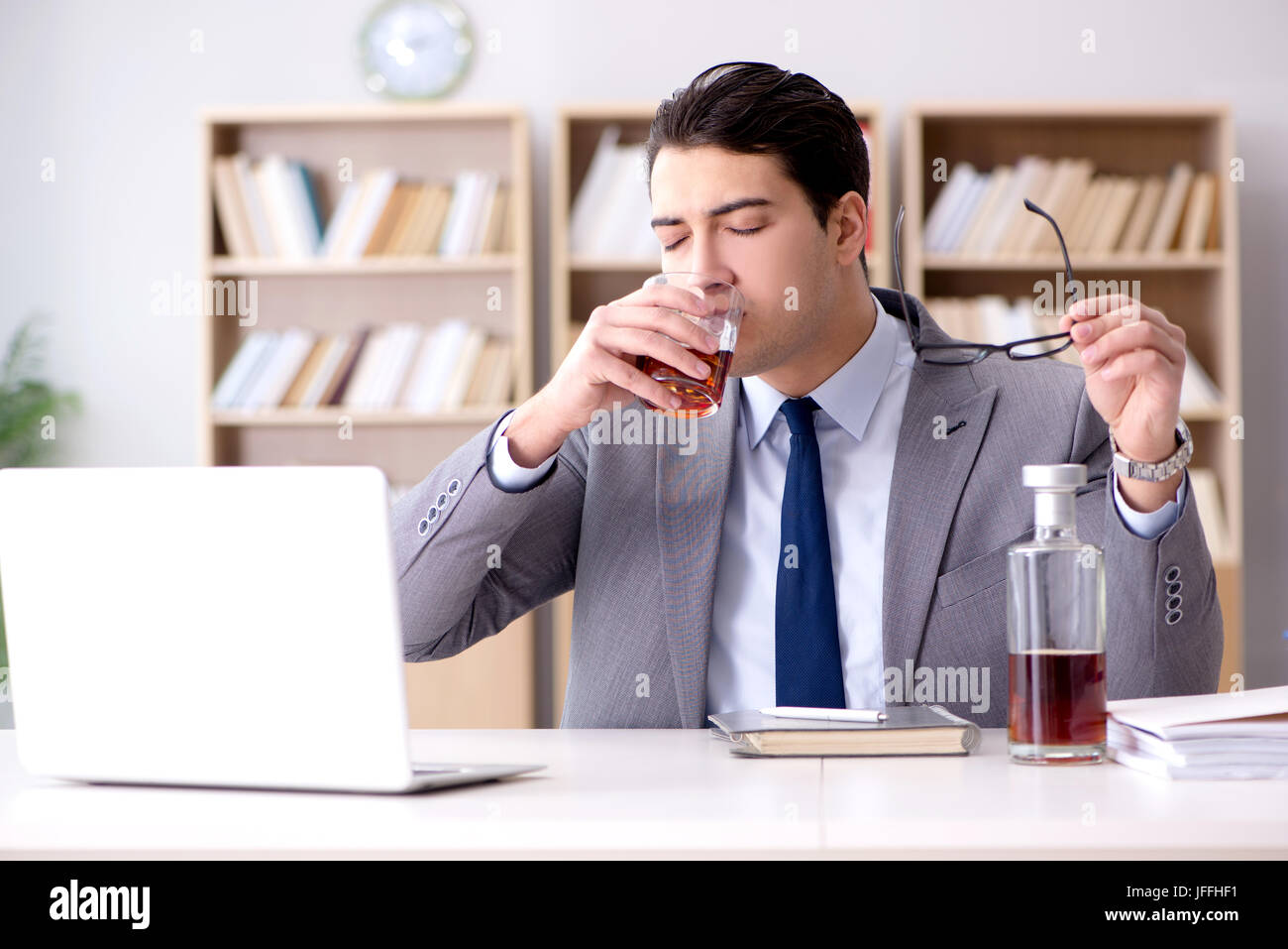 Young businessman drinking from stress Stock Photo - Alamy