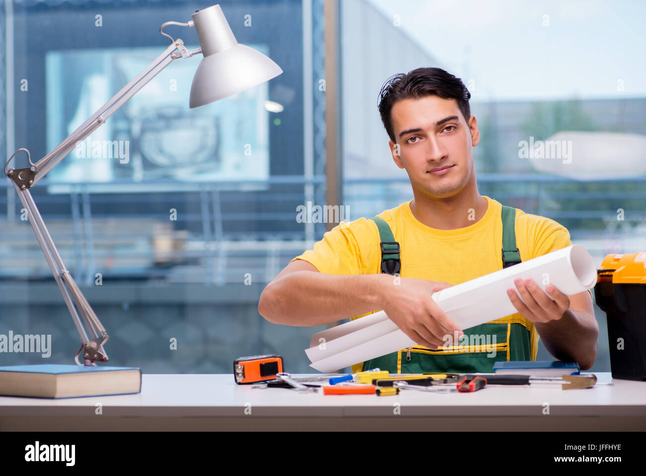 Construction worker sitting at the desk Stock Photo - Alamy