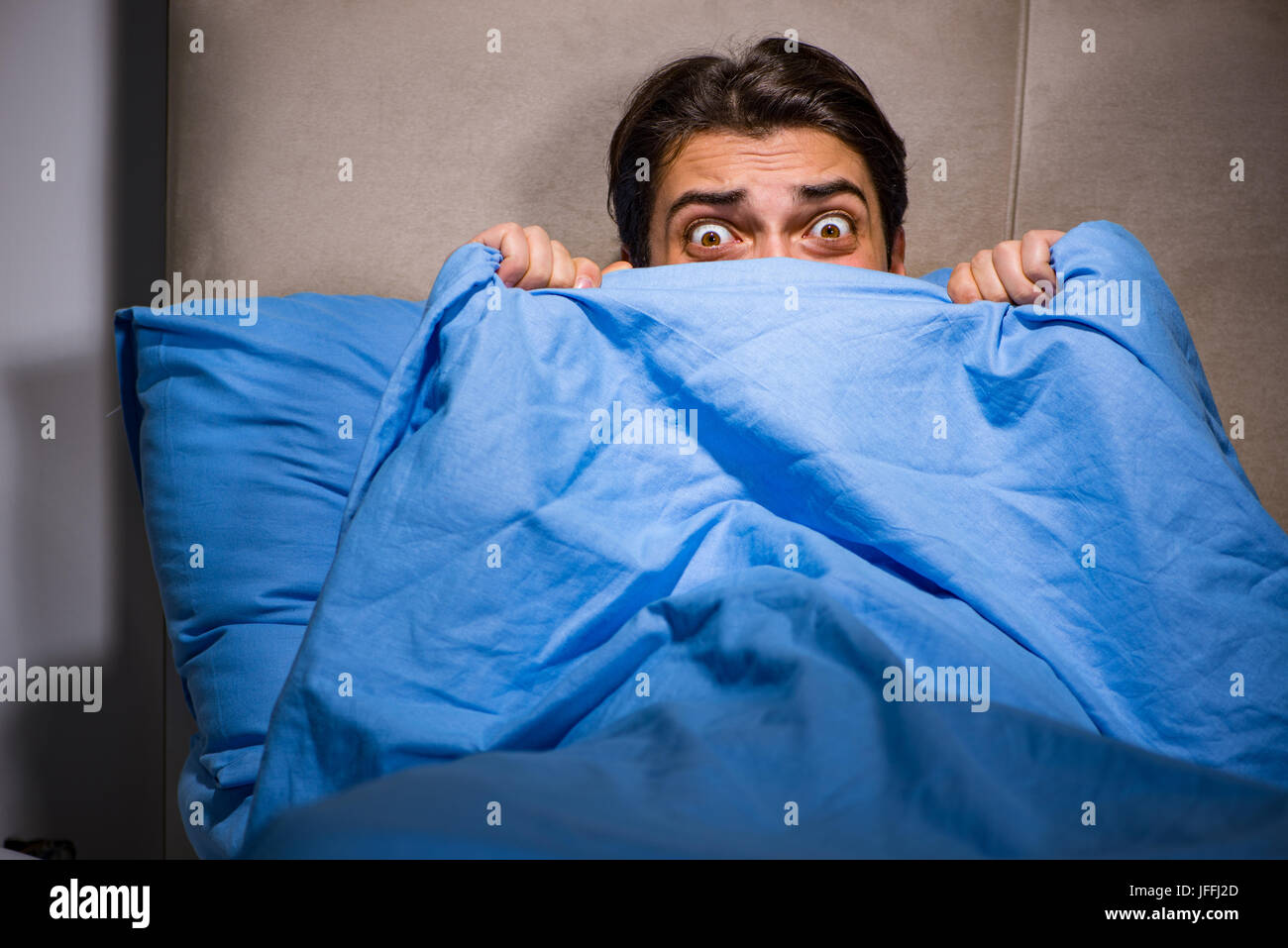 Young man scared in bed Stock Photo - Alamy