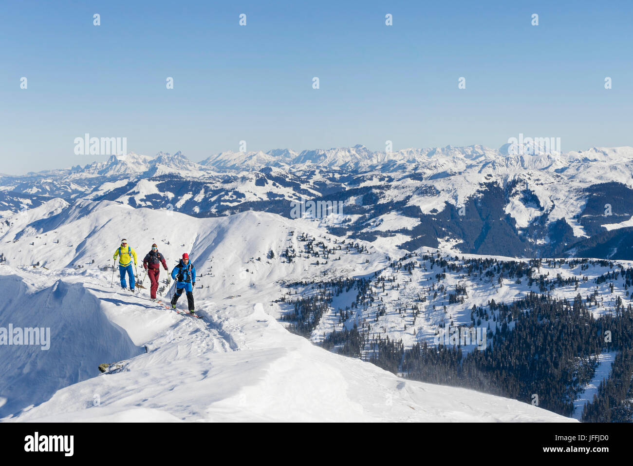 Skiers walking on ridge of snow mountain Stock Photo - Alamy