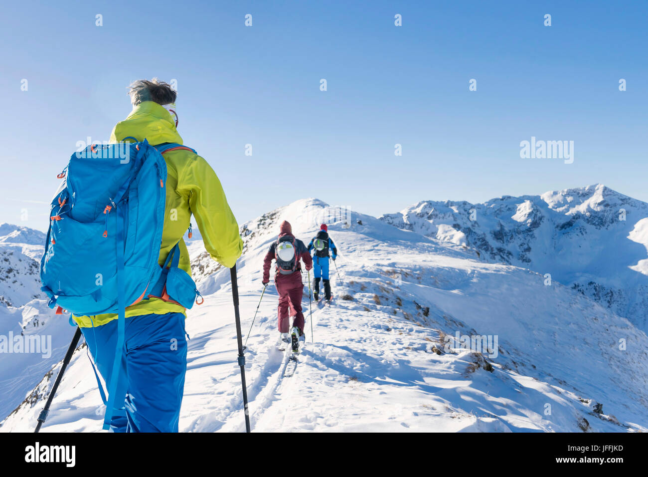 Rear view of skiers walking on ridge of mountain against sky Stock ...