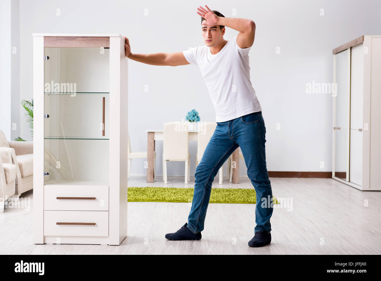 Young man moving furniture at home Stock Photo - Alamy
