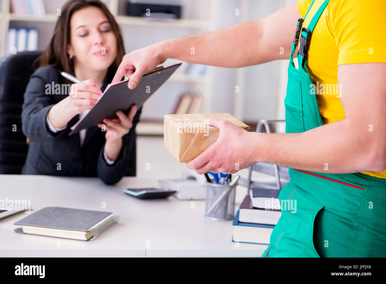 Postman delivering parcel to the office Stock Photo - Alamy
