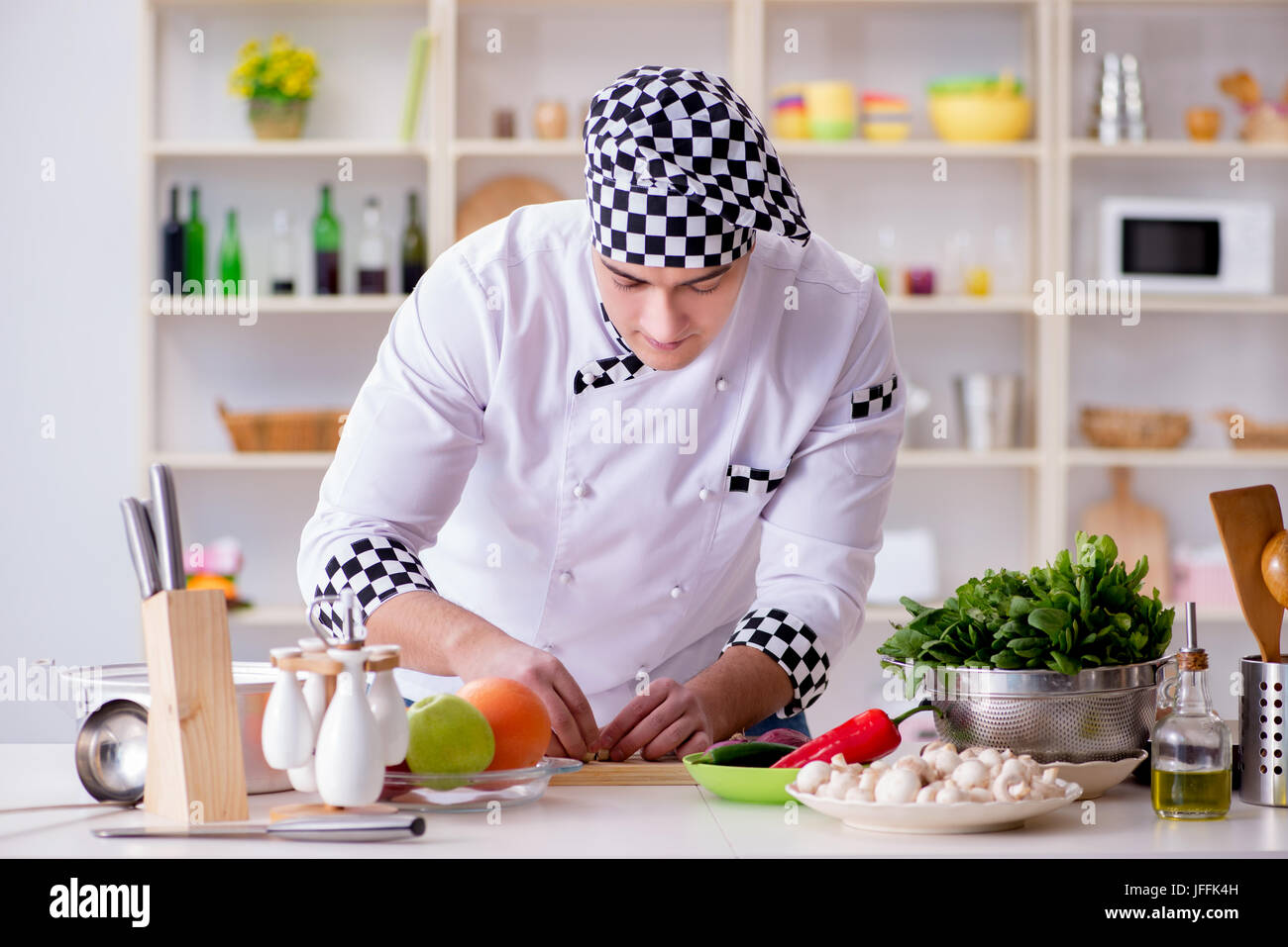 Young male cook working in the kitchen Stock Photo - Alamy