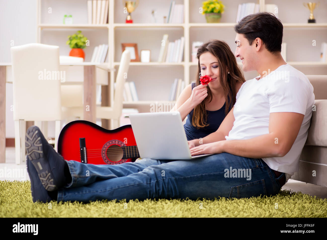 Romantic pair playing guitar on floor Stock Photo - Alamy