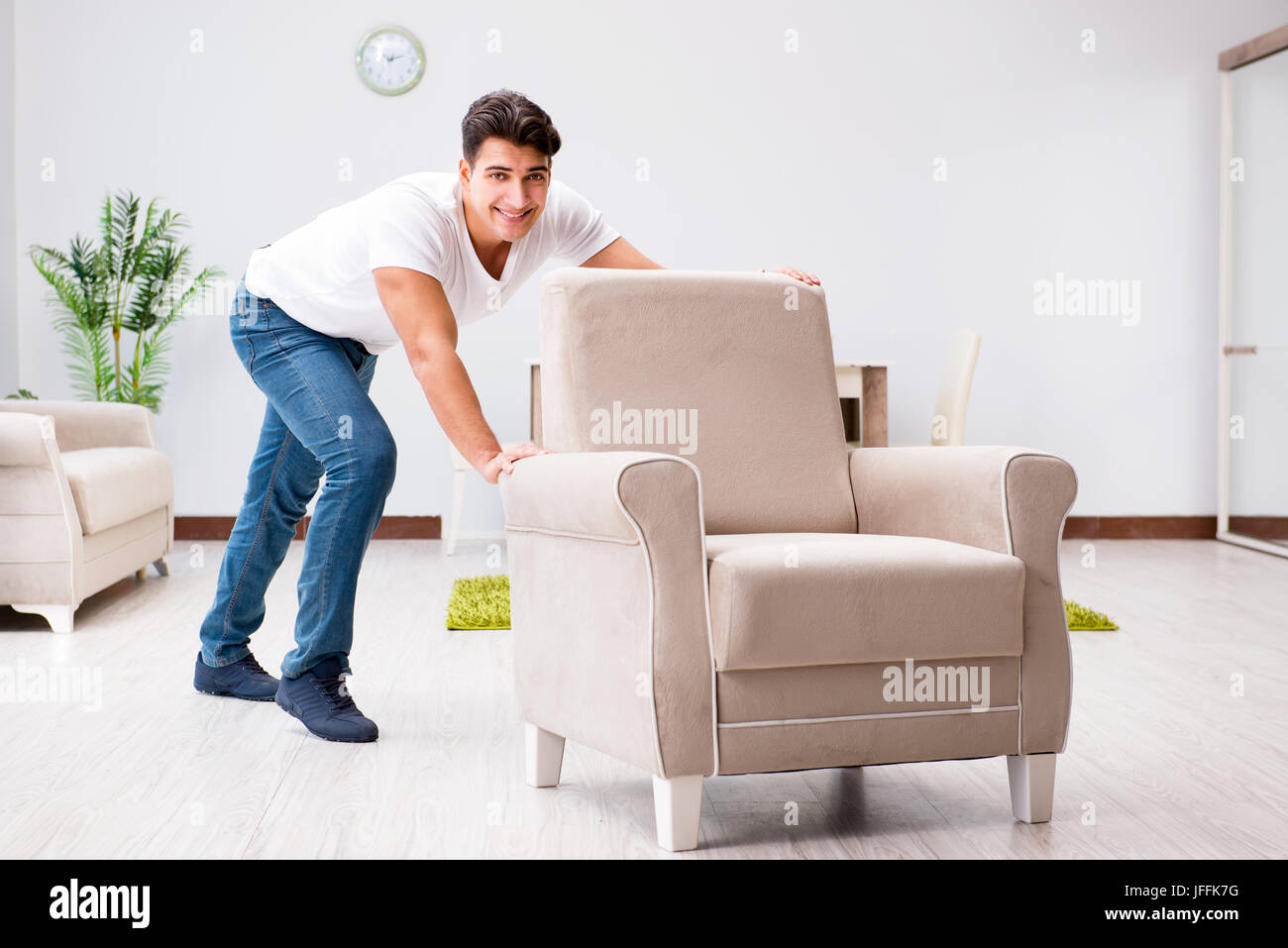 Young man moving furniture at home Stock Photo - Alamy