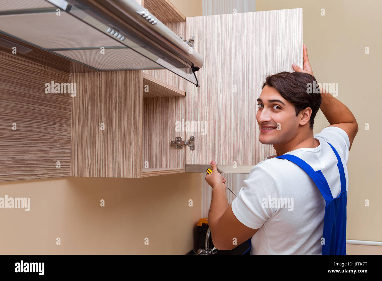 Young man assembling kitchen furniture Stock Photo - Alamy