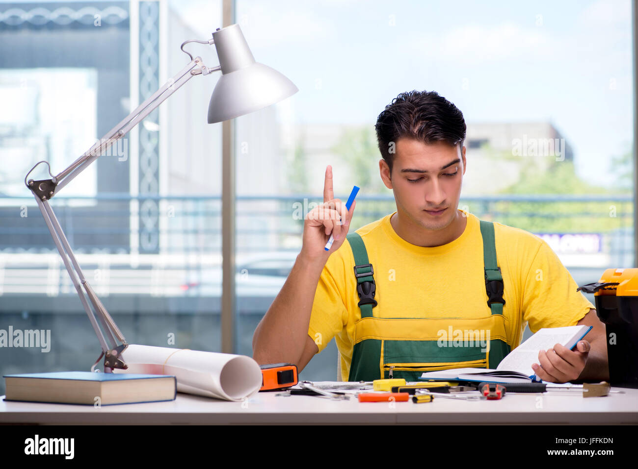 Construction worker sitting at the desk Stock Photo - Alamy