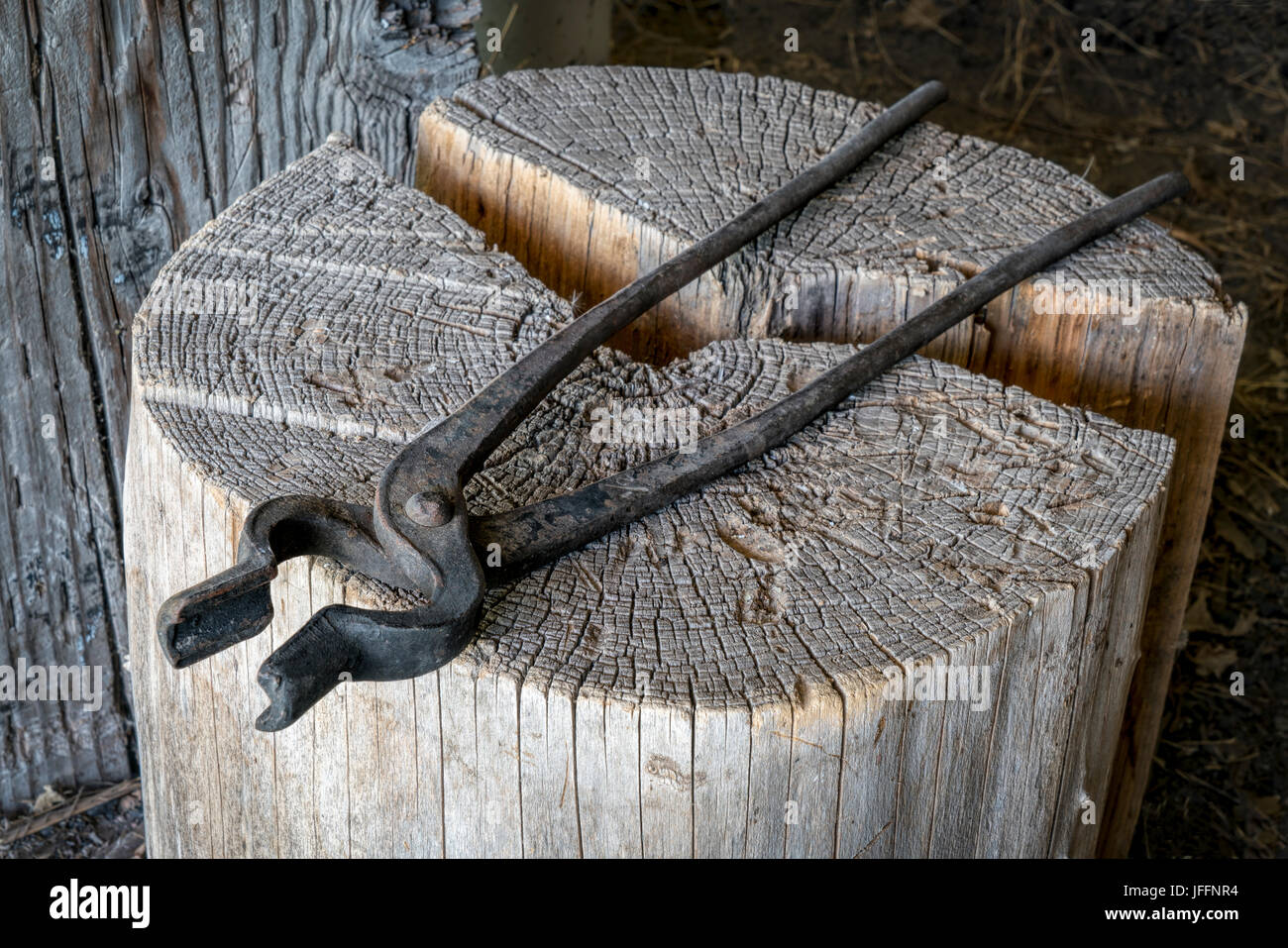 Vintage blacksmith pliers on wooden log in an old workshop Stock Photo ...