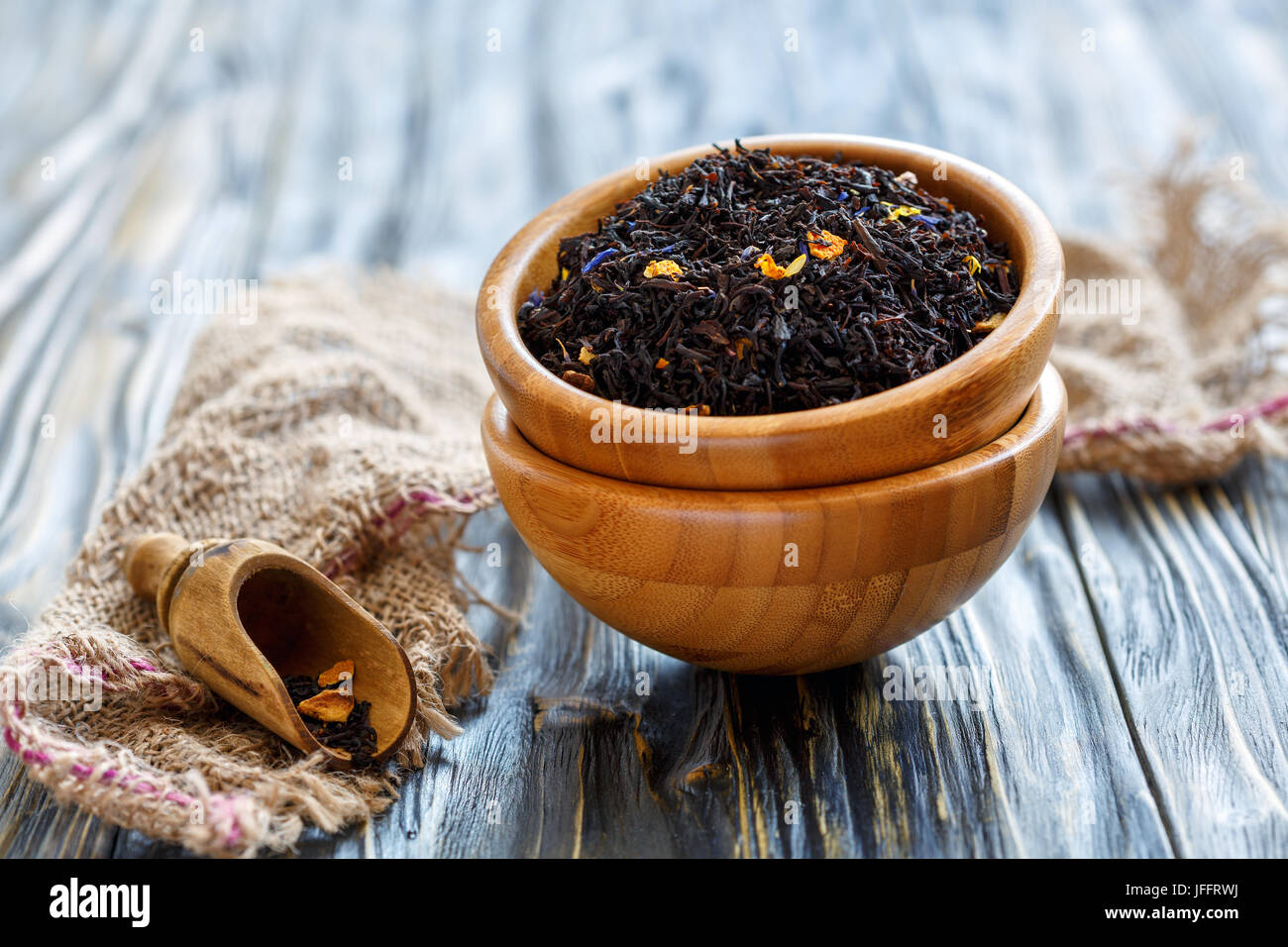 Black tea with bergamot and flower petals in wooden bowls Stock Photo ...