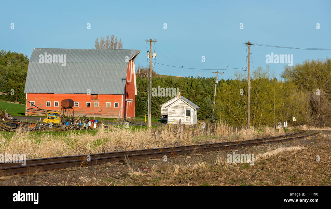 Red barn with green trees located near train tracks Stock Photo - Alamy