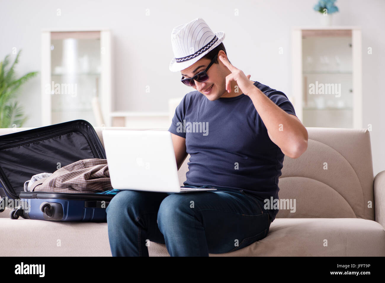 Man going on vacation packing his suitcase Stock Photo - Alamy